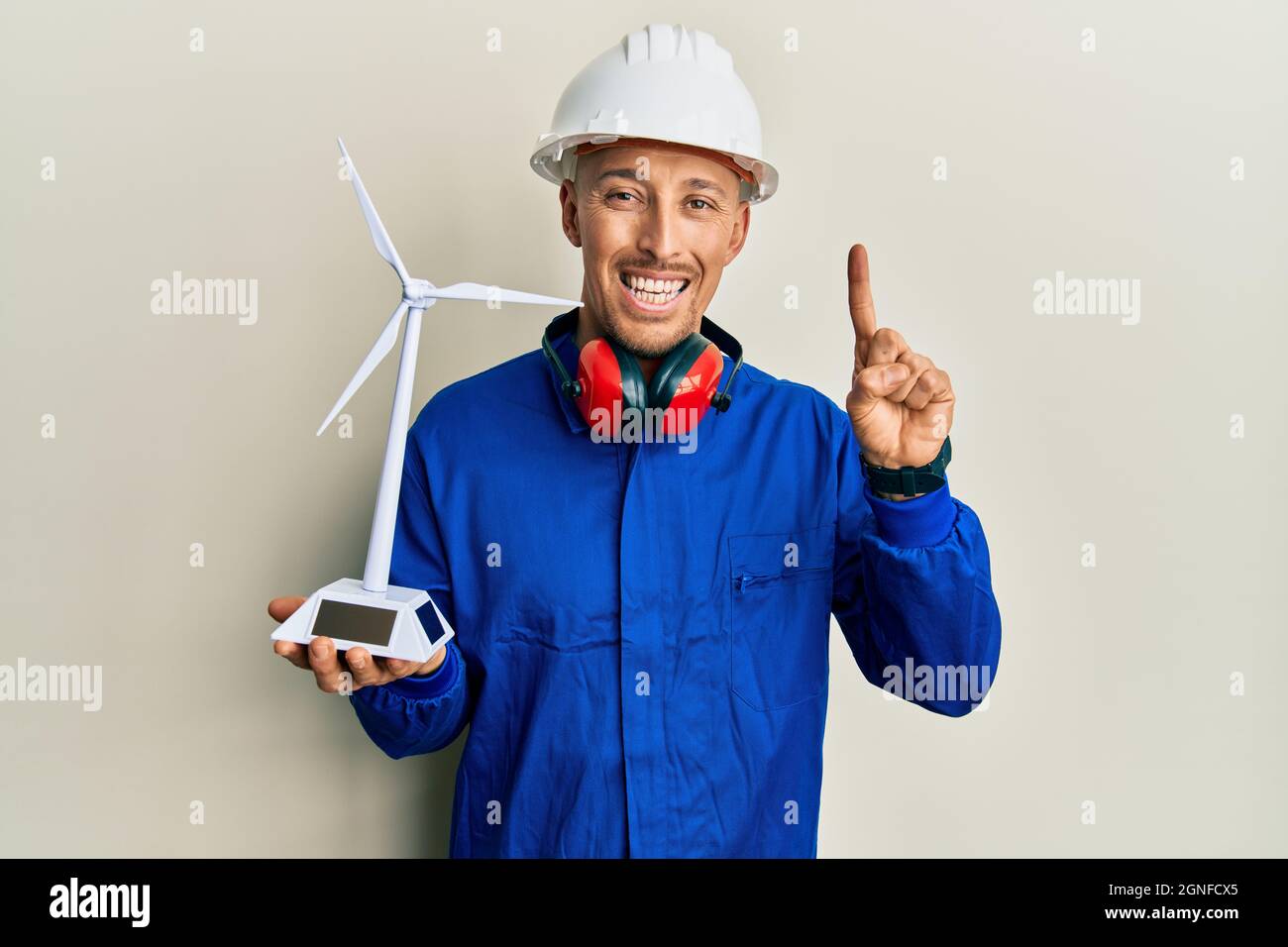 Bald engineer man with beard holding solar windmill for renewable ...
