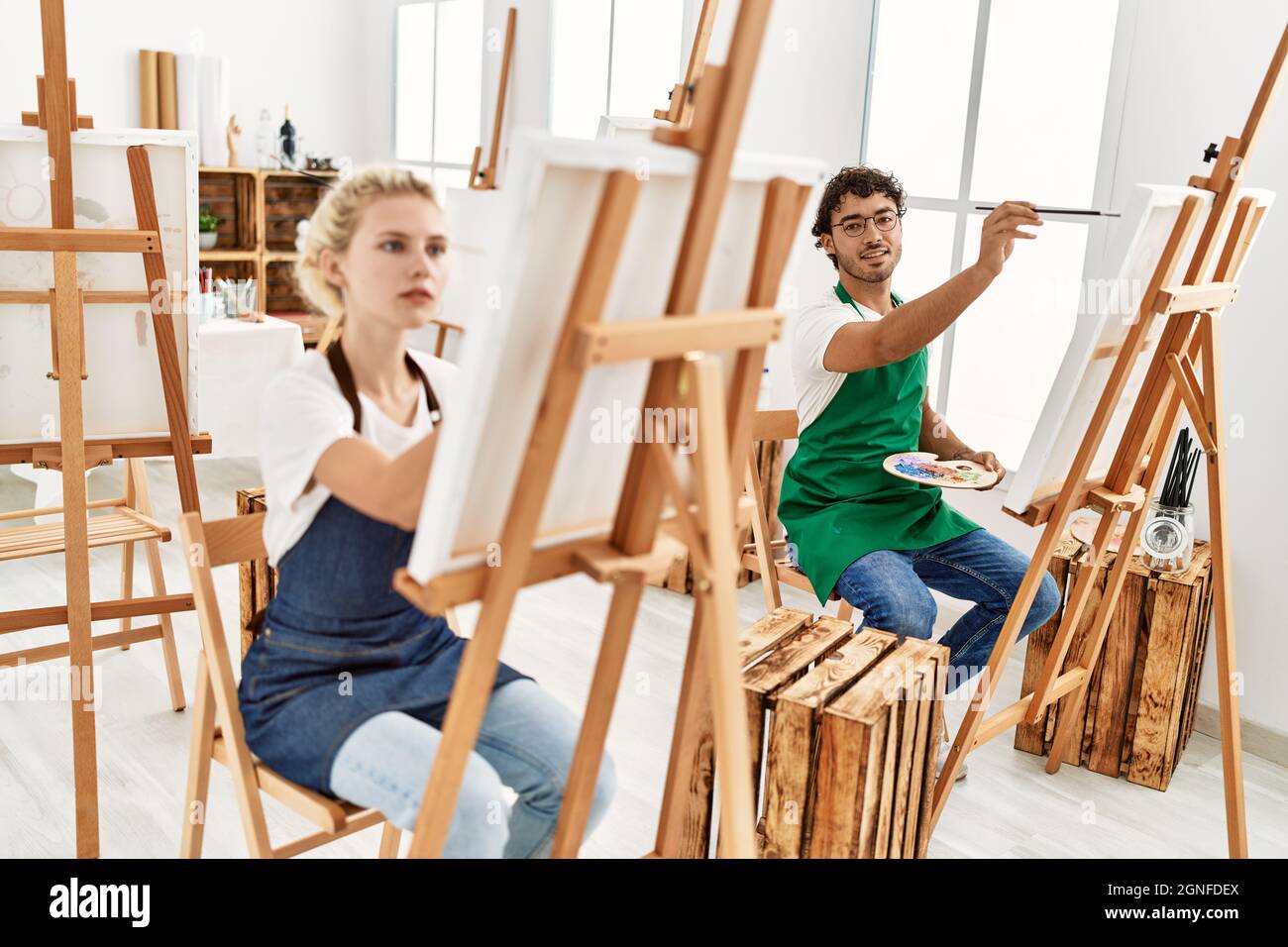 Young artist couple smiling happy painting at art studio Stock Photo ...