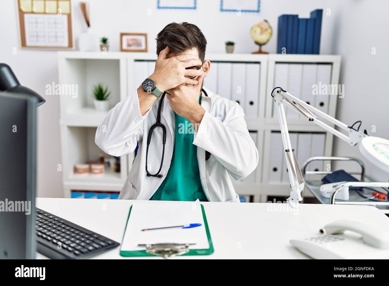 Young man with beard wearing doctor uniform and stethoscope at the ...