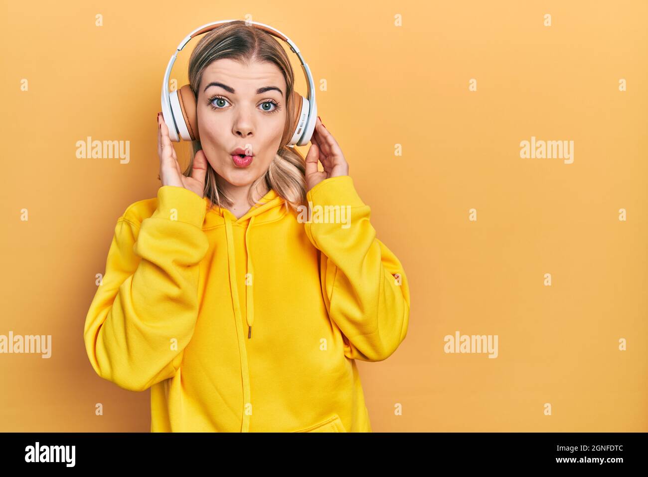 Beautiful caucasian woman listening to music using headphones scared ...