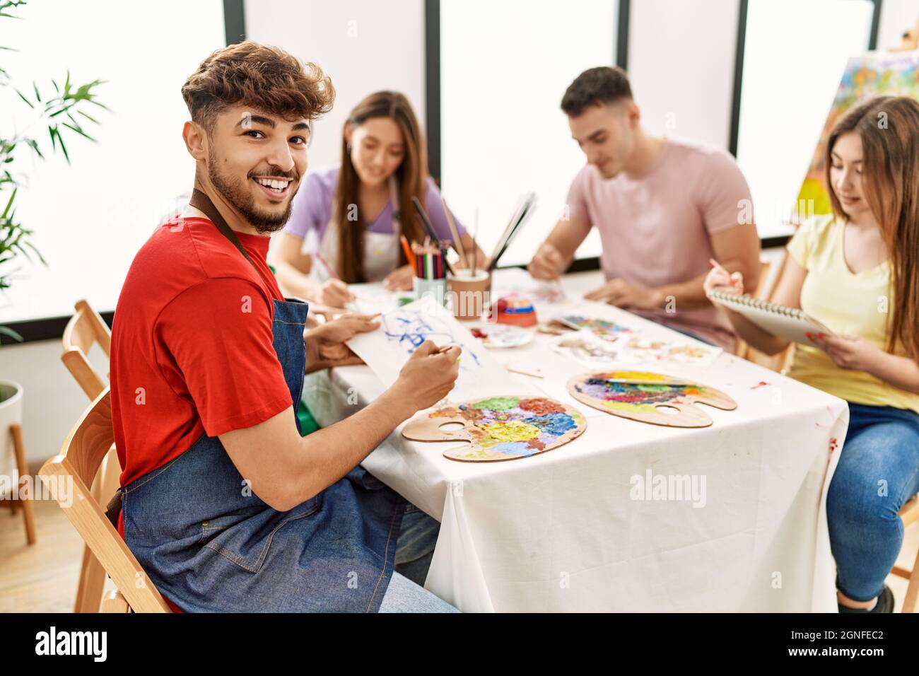 Group of people drawing sitting on the table. Young man smiling happy ...
