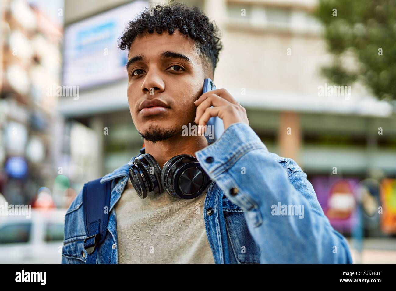 Hispanic young man speaking on the phone at the street Stock Photo - Alamy