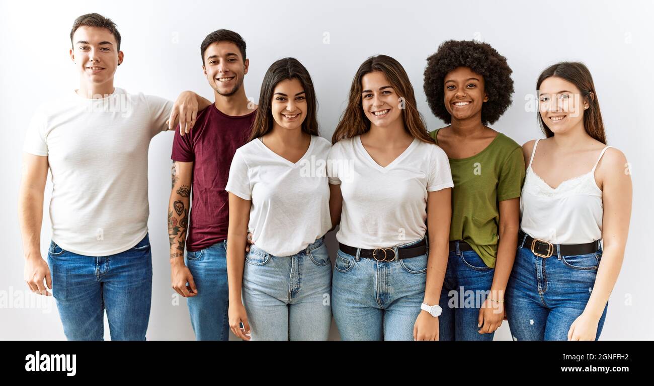 Group of young friends standing together over isolated background with ...