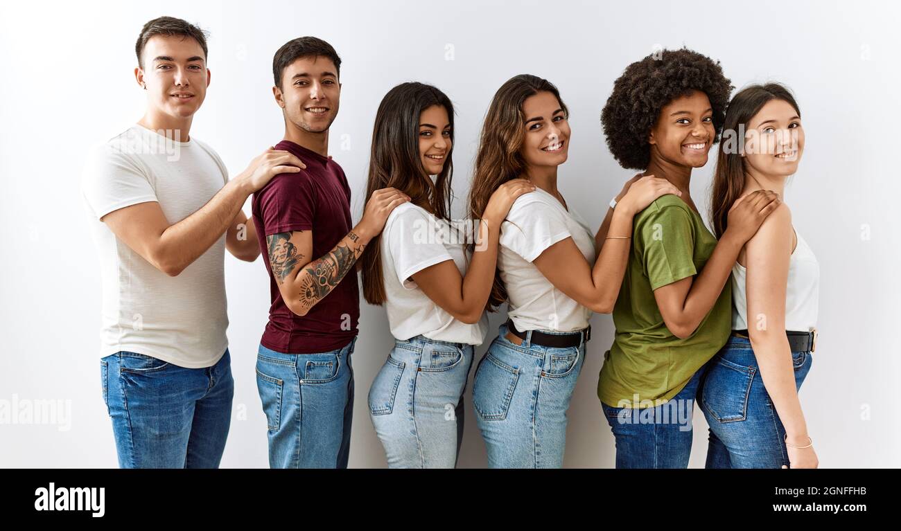 Group of young friends standing together over isolated background ...