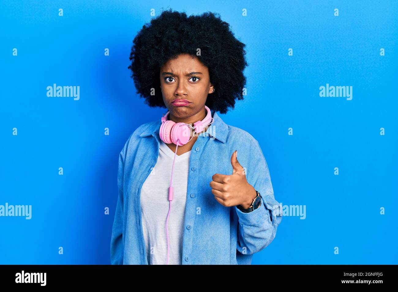 Young african american woman wearing headphones doing thumbs up ...