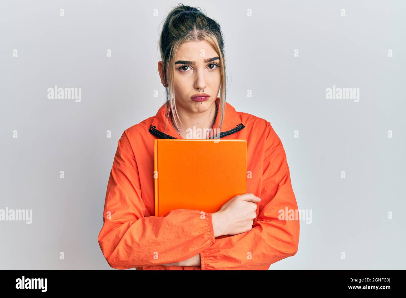 Young modern girl holding book depressed and worry for distress, crying ...