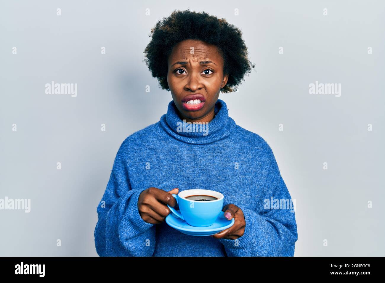 Young african american woman drinking a cup of coffee clueless and ...