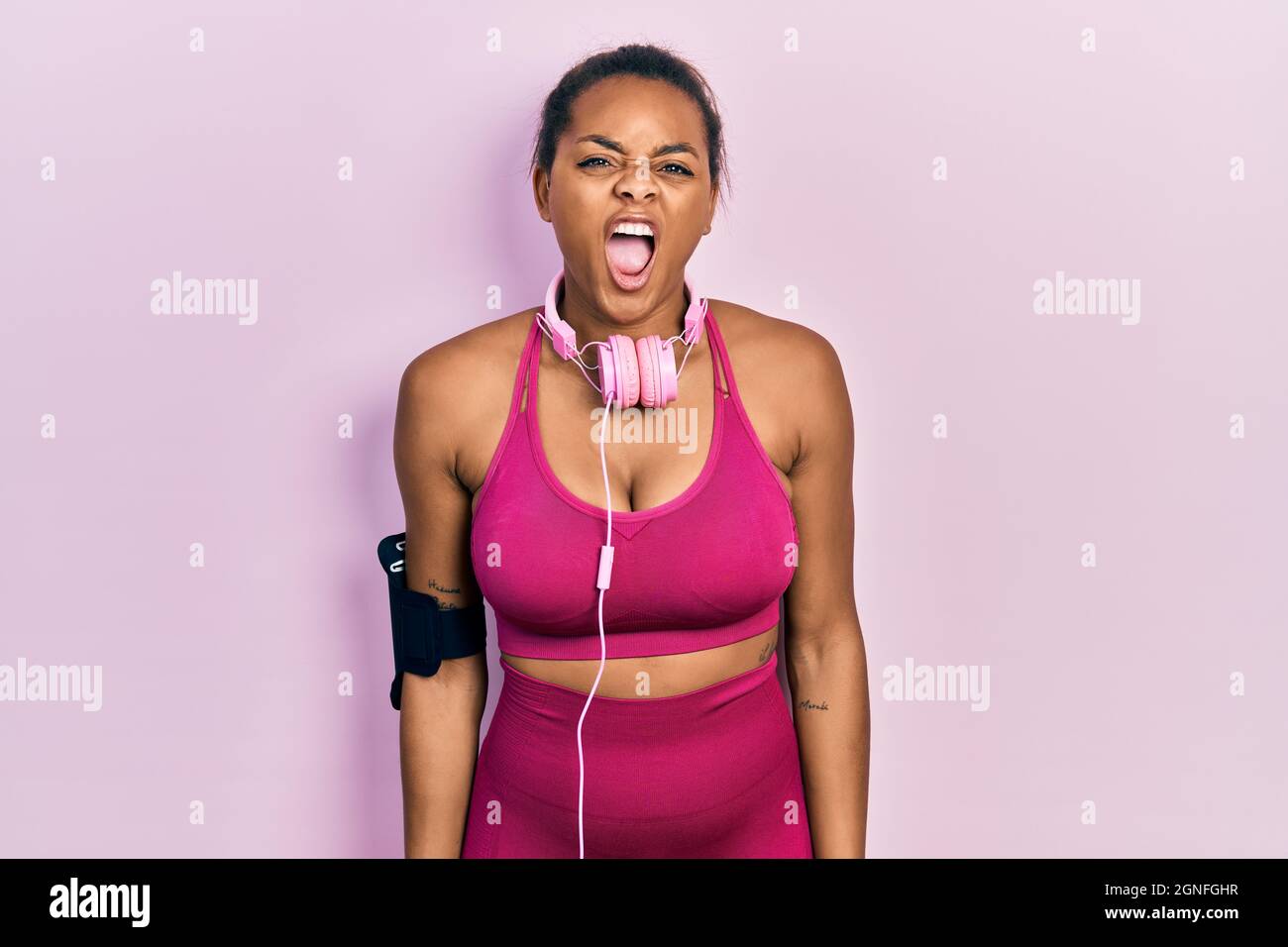 Young african american girl wearing gym clothes and using headphones ...