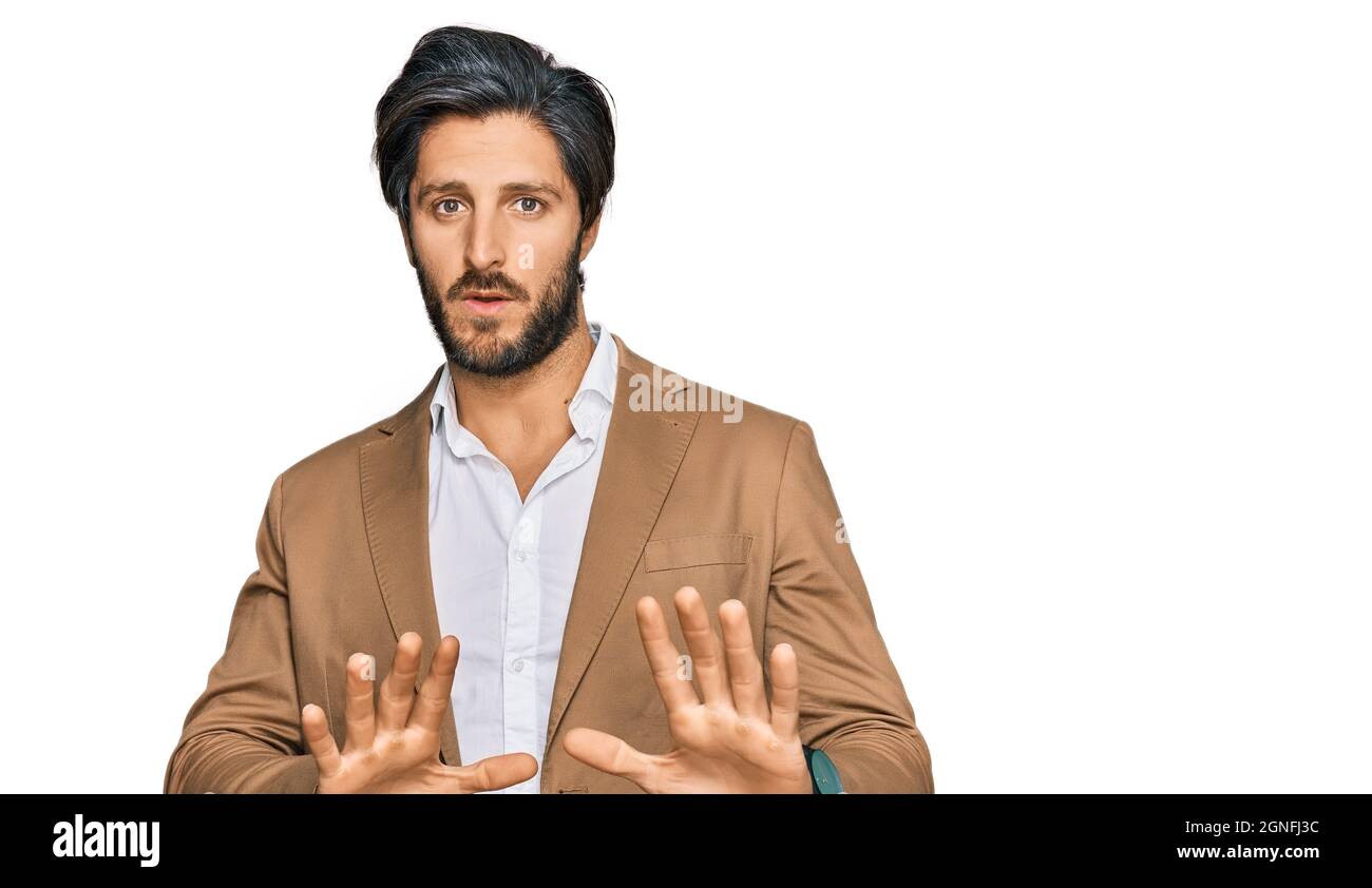 Young hispanic man wearing business clothes moving away hands palms ...