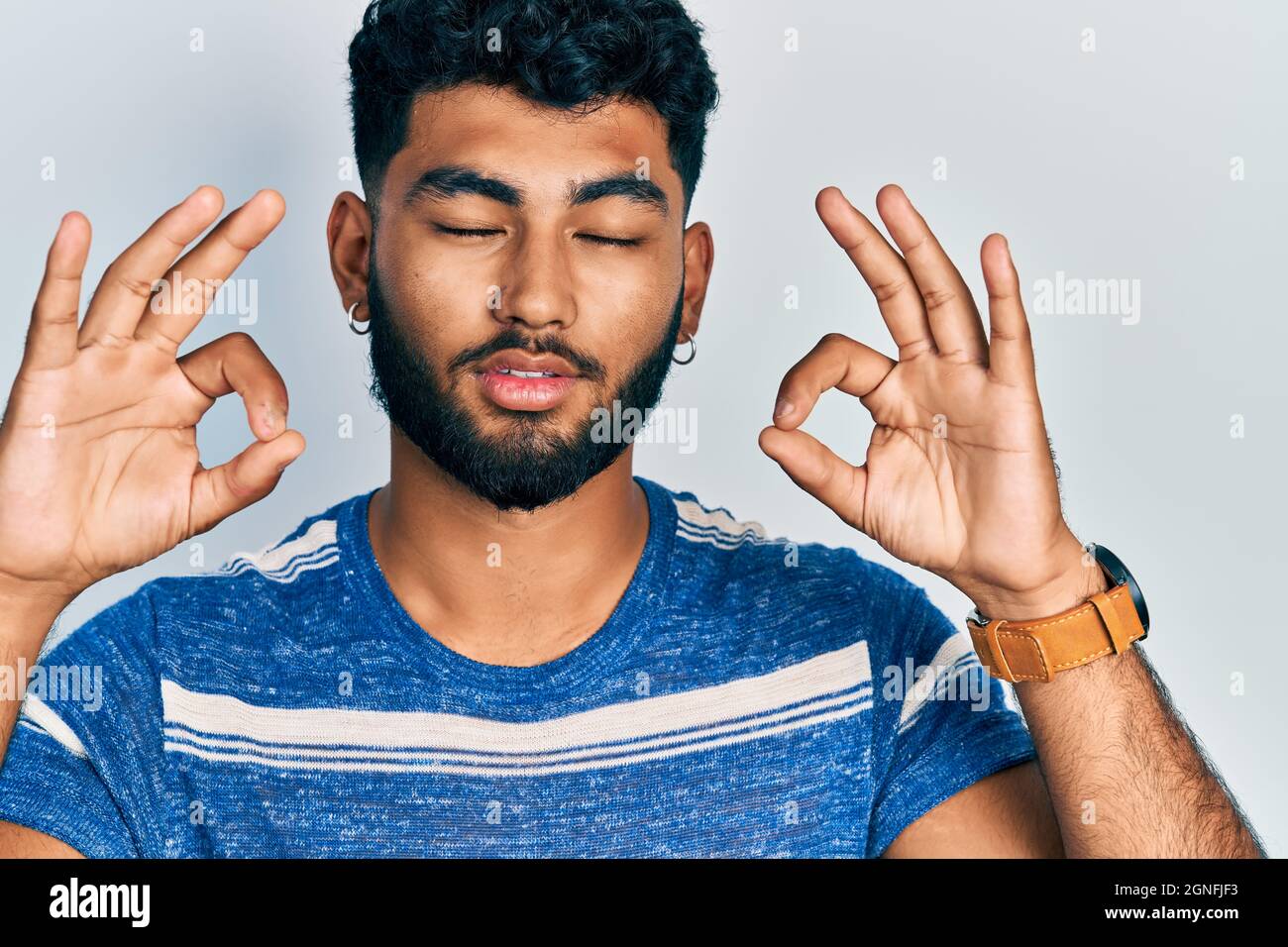 Arab man with beard wearing casual striped t shirt relax and smiling ...