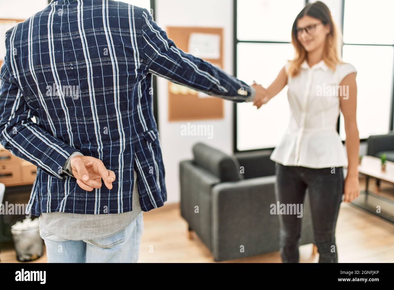 Two business workers smiling happy shaking hands. Man standing with ...
