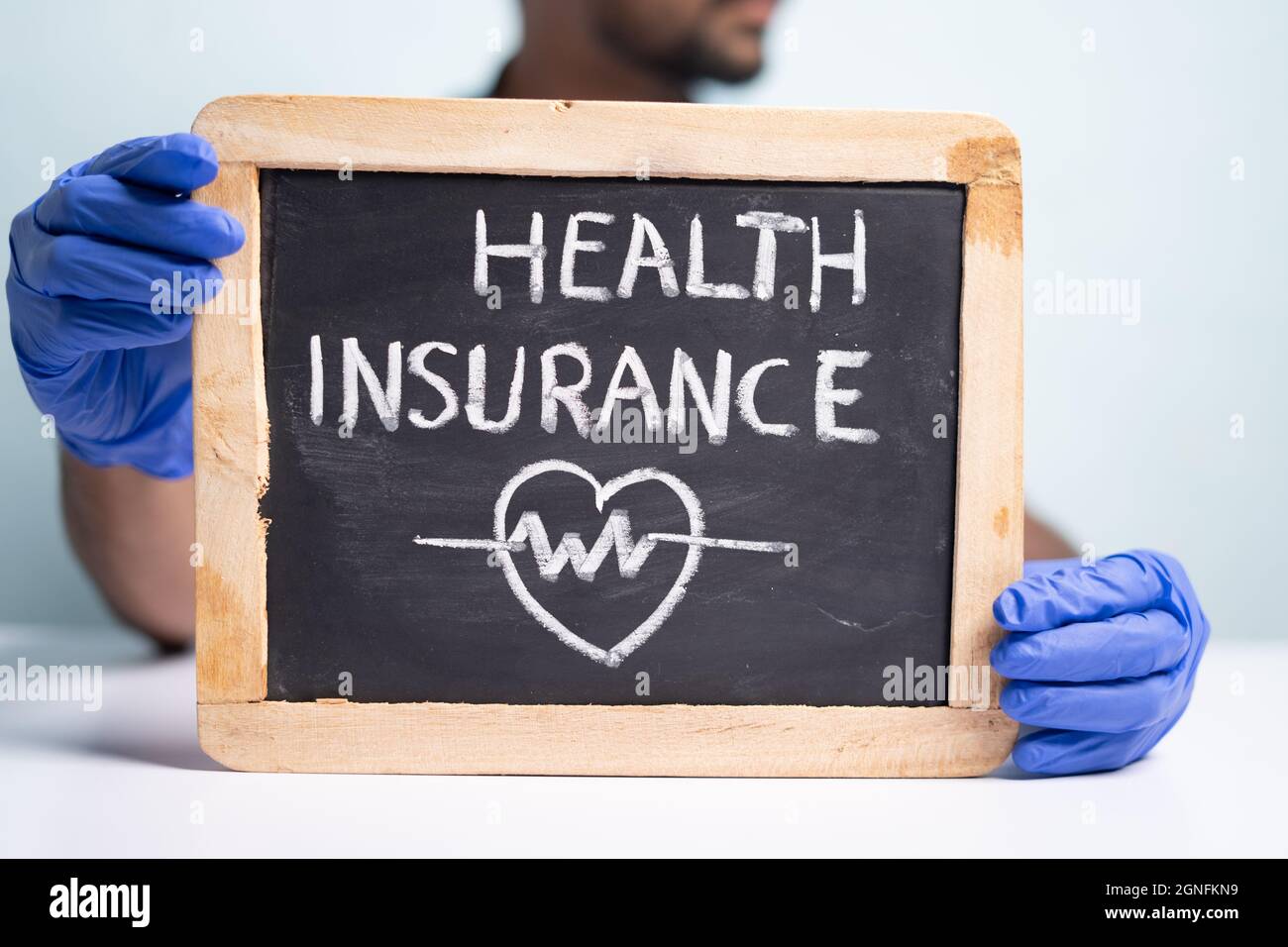 Unrecognized doctor showing or recommending health insurance sign board ...