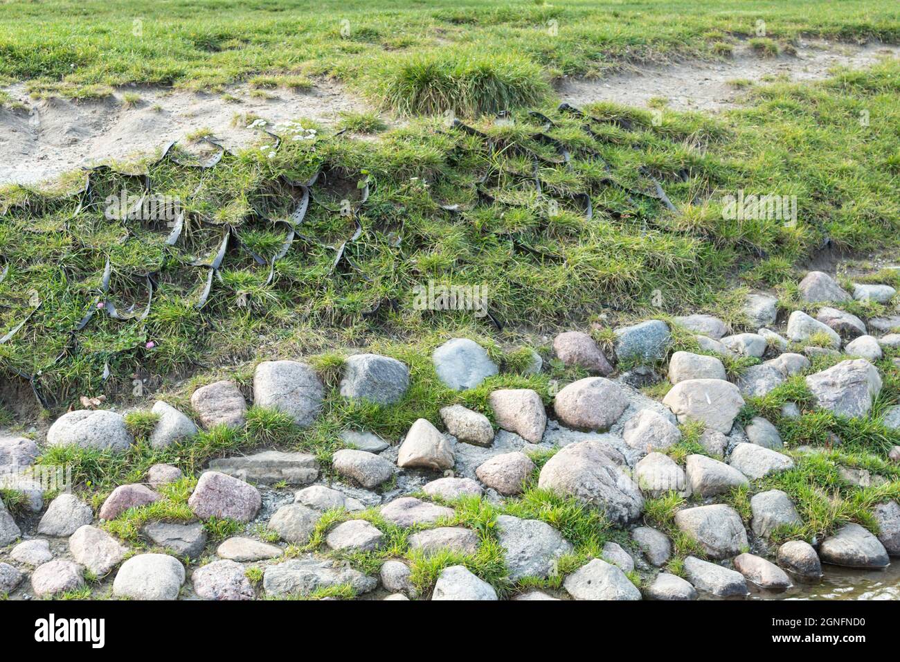 Fortification on the river bank. A stream bank with a stone gabion wall ...