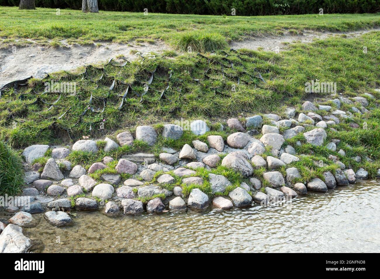 Fortification on the river bank. A stream bank with a stone gabion wall ...
