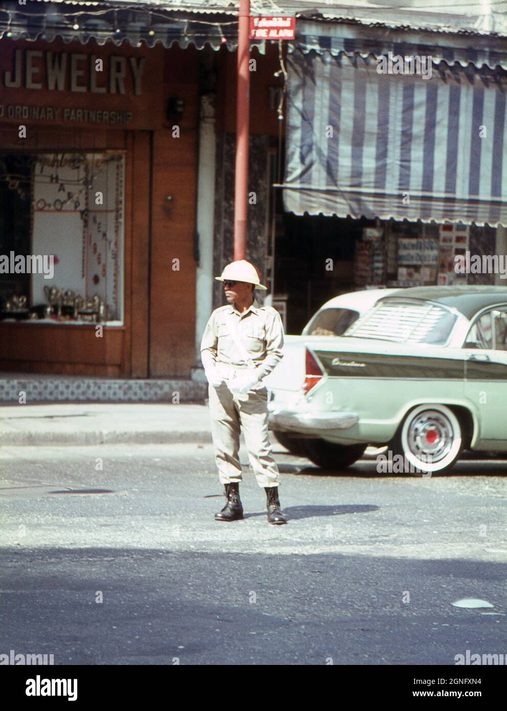 A Thai traffic policeman wearing a pith helmet and sunglasses. Charoen ...