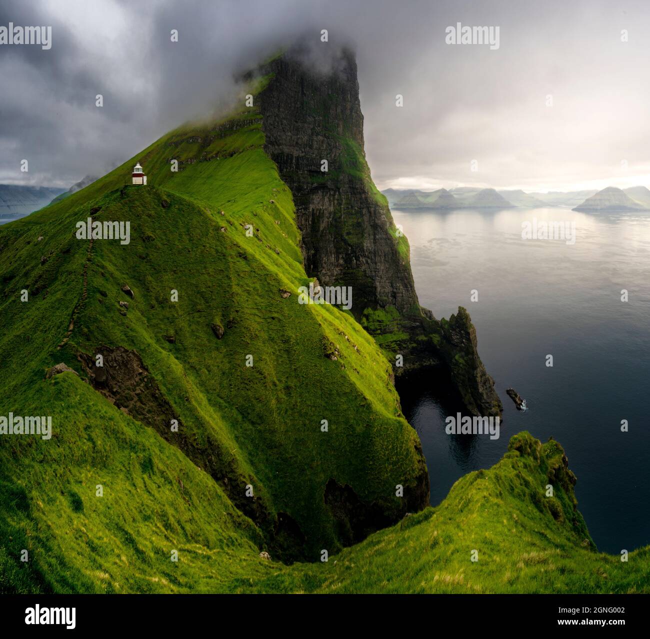The epic and dramatic sea cliffs by the Kallur Lighthouse on Kalsoy ...