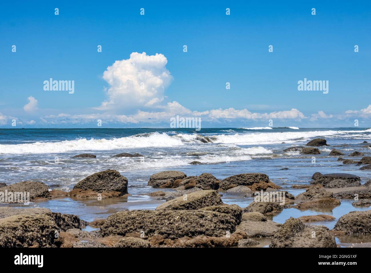 Landscape view of a beautiful sea beach with blue sky, rocks, and water ...