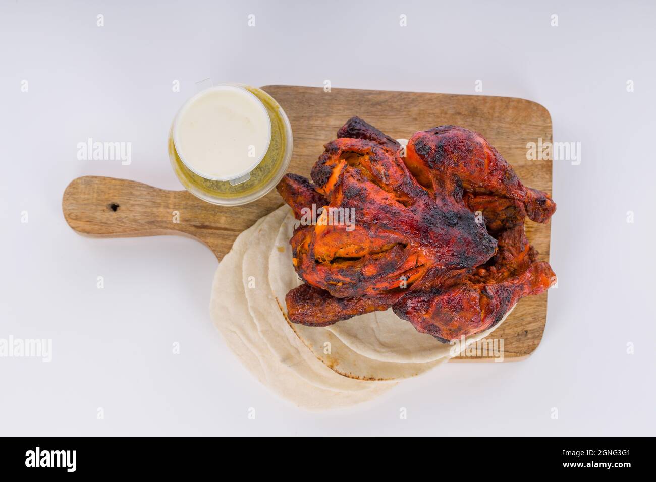 Shawai chicken arranged on a wooden base with kuboos and side dishes ...