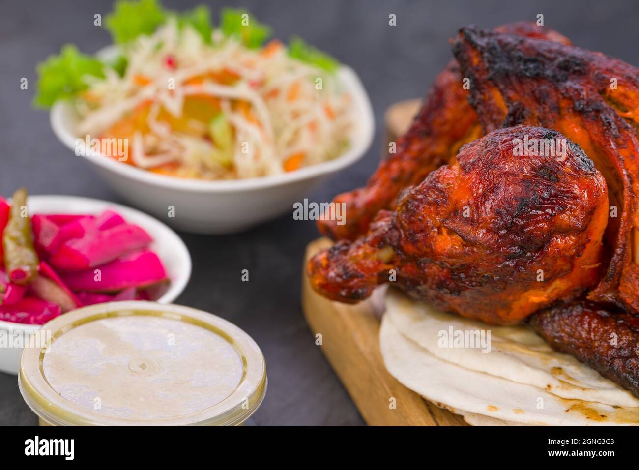 Shawai chicken arranged on a wooden base with kuboos and side dishes on ...