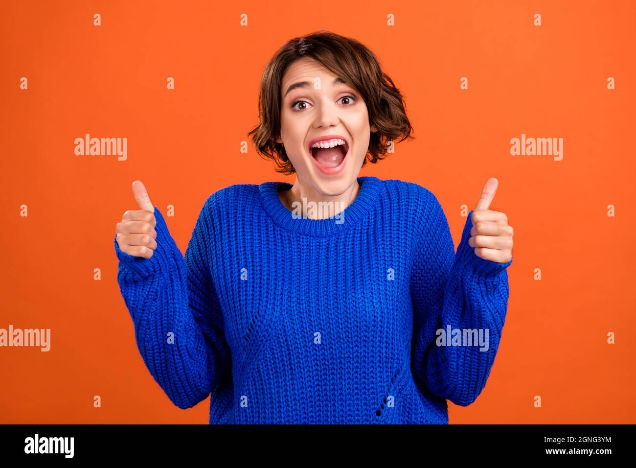 Portrait of attractive successful cheerful girl showing thumbup ad ...