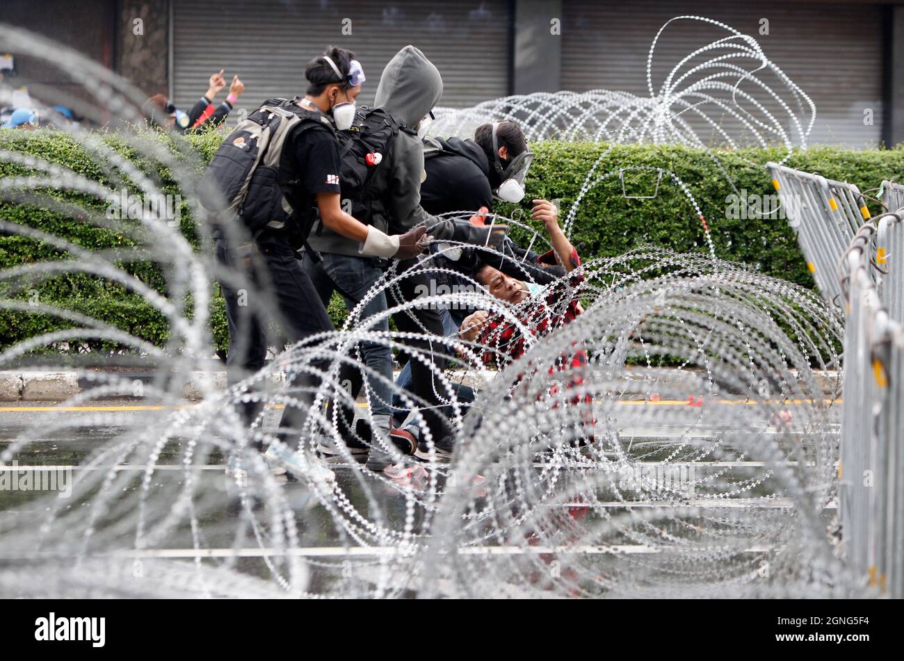 Protesters help their colleague who fell on a wire barricade during the ...