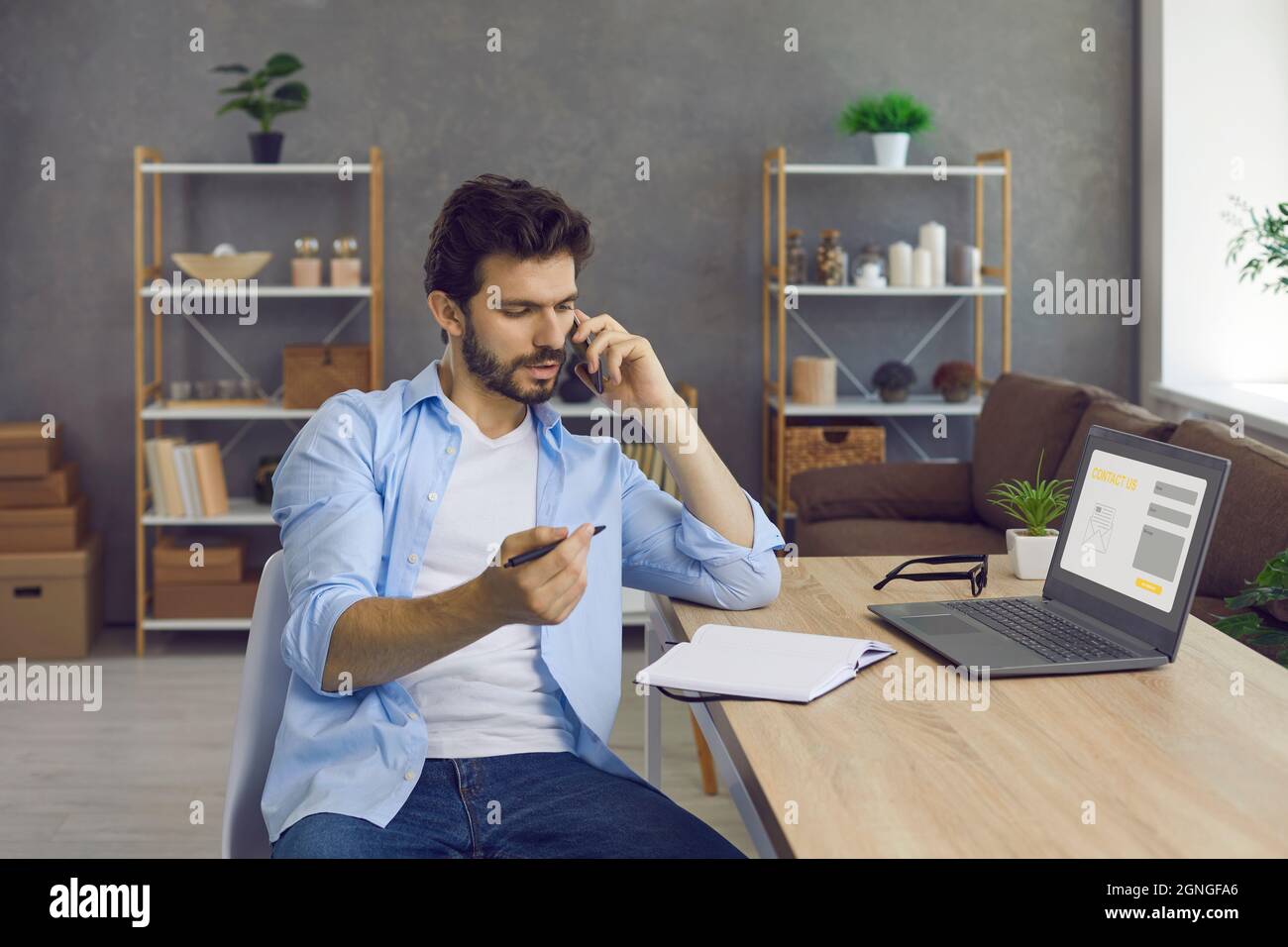 Serious young entrepreneur has a business conversation on the phone and ...