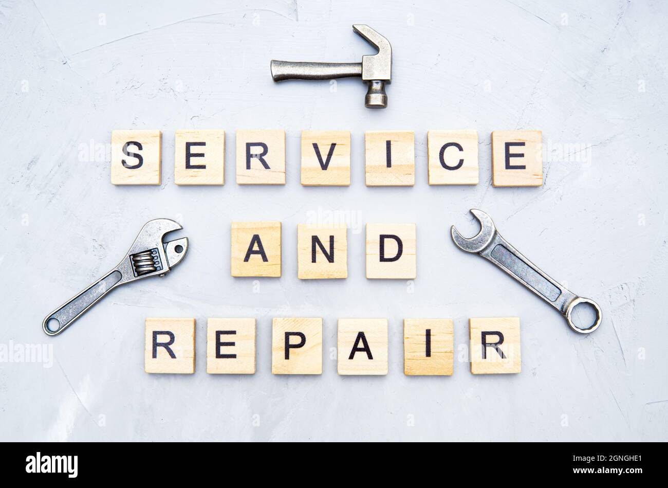 Words REPAIR and SERVICE made of wooden letter tiles and small steel ...