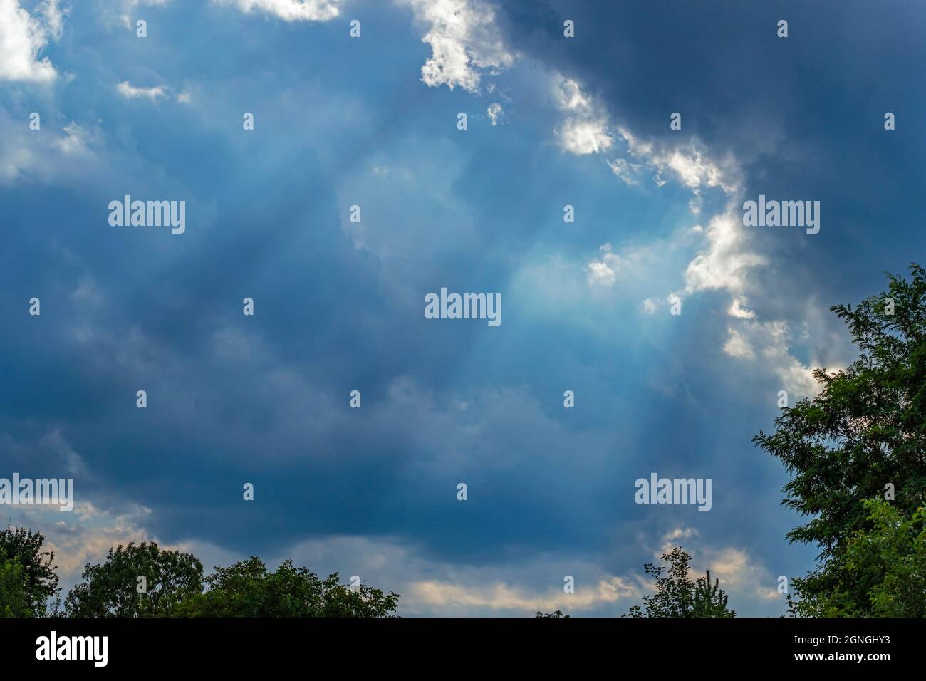 Rain, dramatic heavy clouds with sun rays coming thru Stock Photo - Alamy