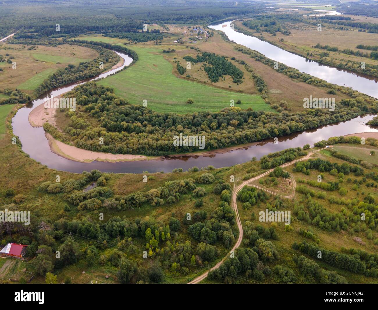 River between wavy road and lawns with trees in countryside Stock Photo ...