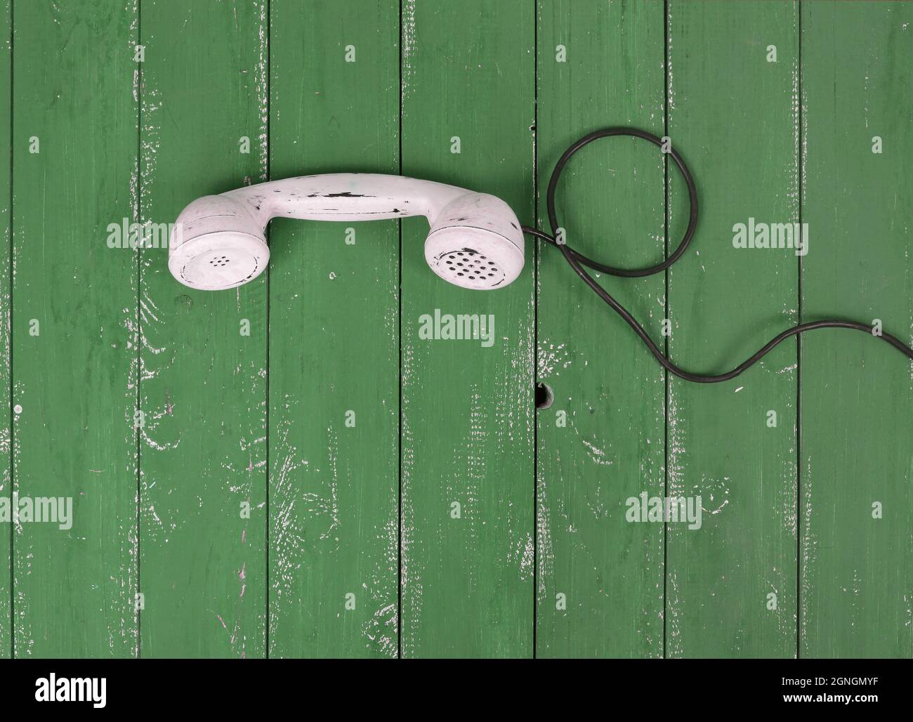 Top view White handset vintage phone on a retro old green wood textured ...