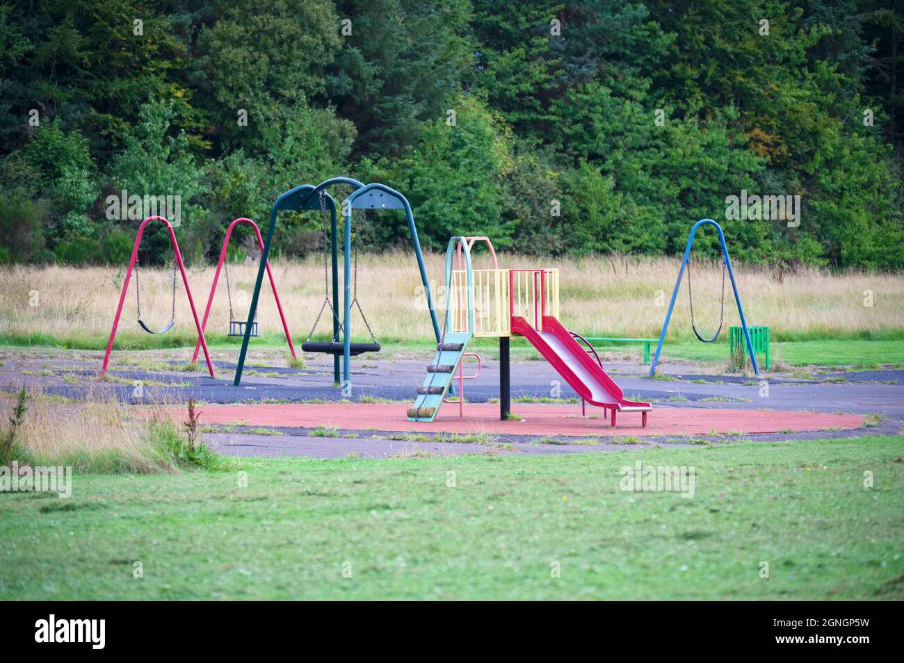 Empty playground derelict swings and slide in rural area Stock Photo ...