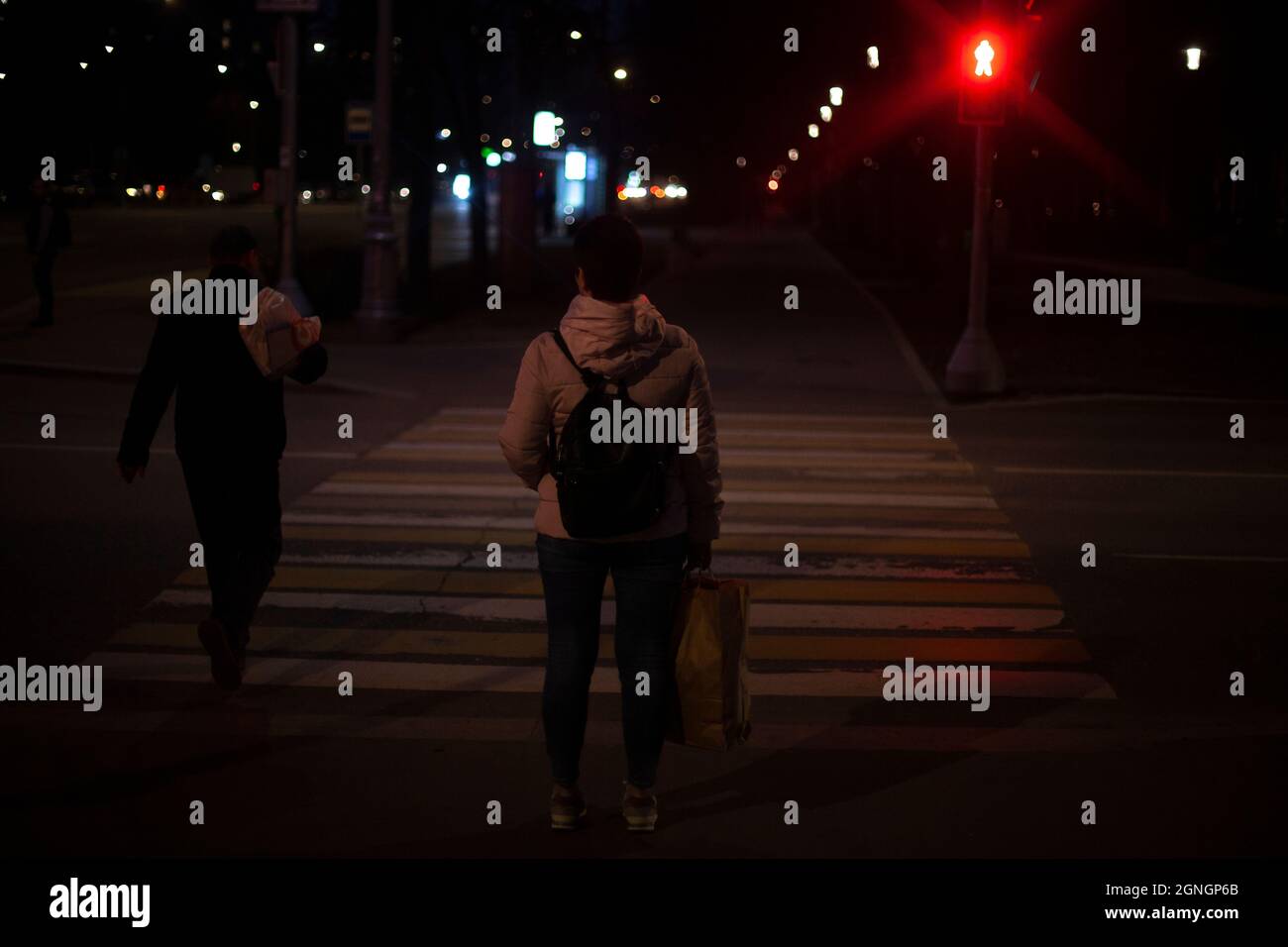 People are outside at night. Crossing the road at night. Walk the ...