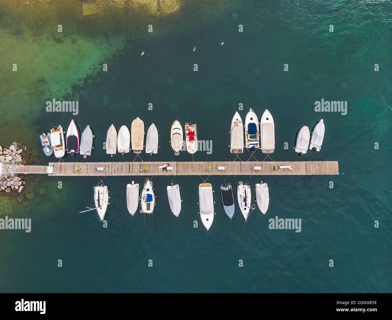 A top view of fishing boats anchoring in marina next to jetty wooden ...