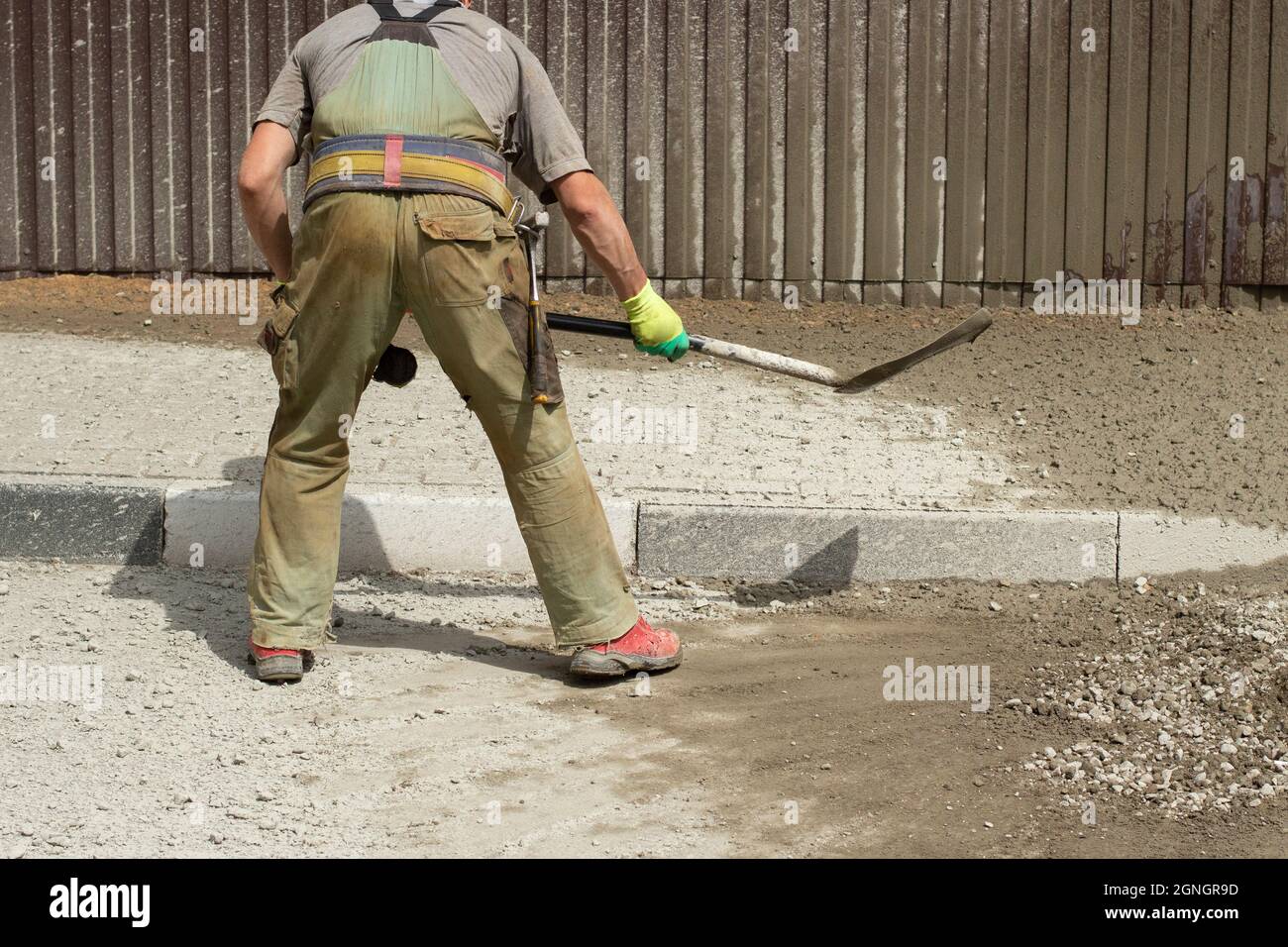 Work with a shovel at a construction site. A worker throws cement and ...