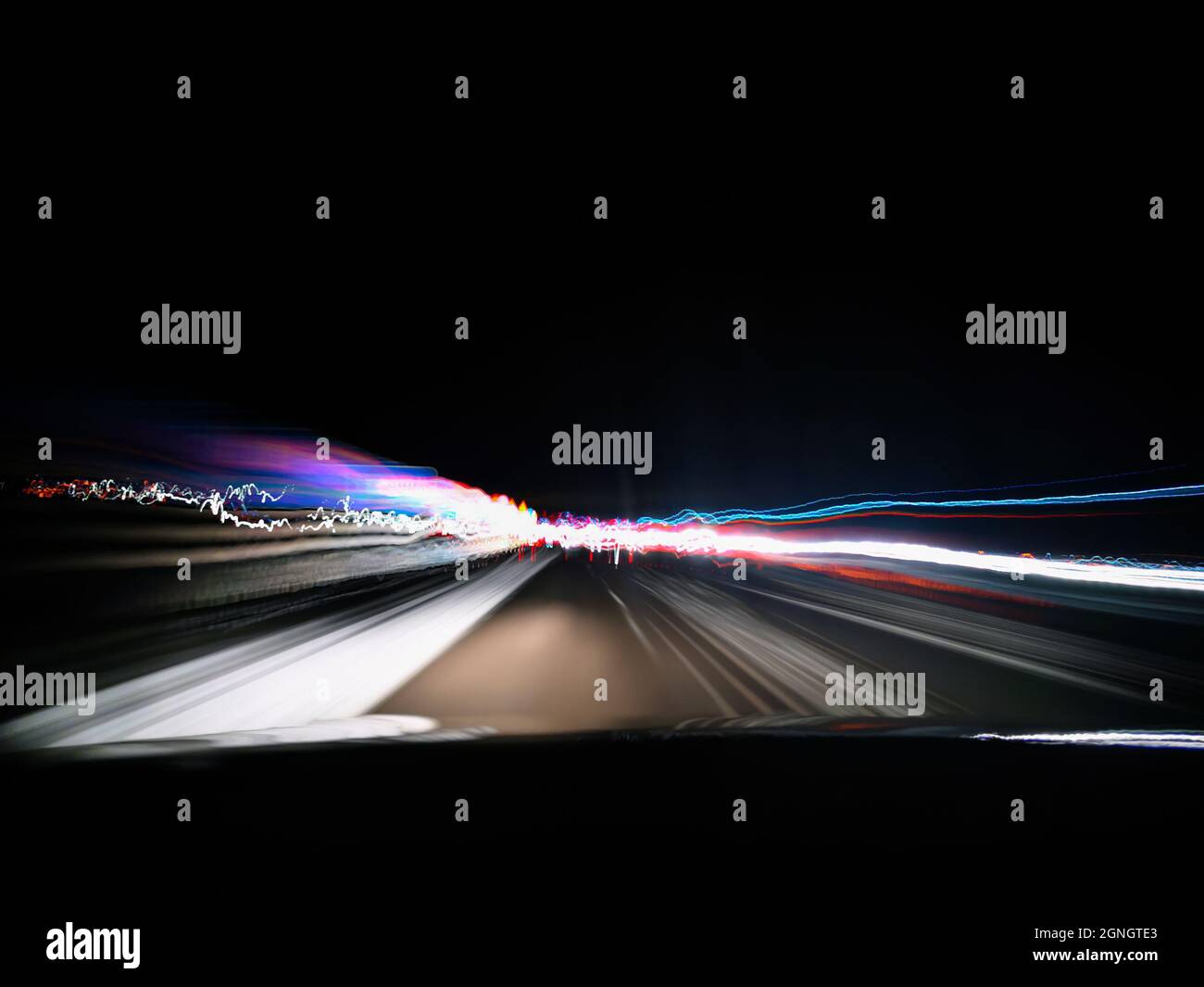 View of night highway neon lights on long exposure from car's front ...