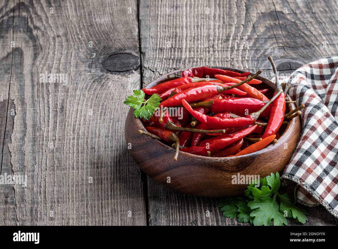 red spicy marinated pepper in wooden bowl on the rustic table Stock ...