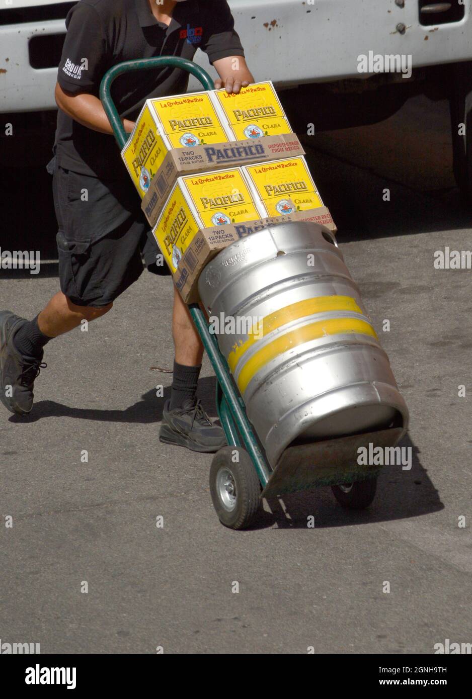 A beer deliveryman with a hand truck delivers cartons of Pacifico ...