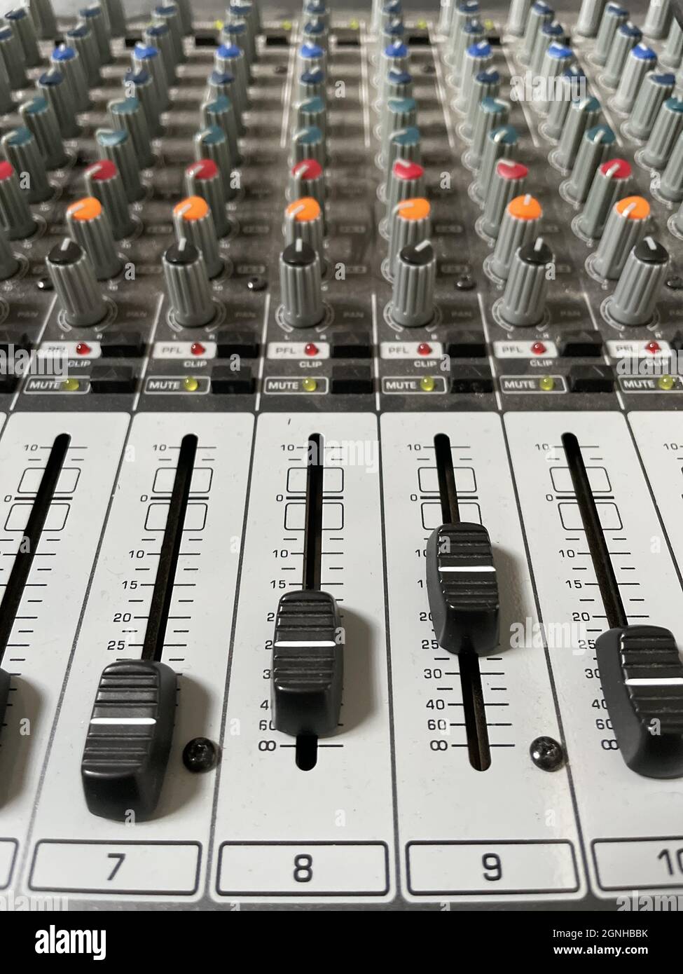 Vertical closeup shot of various buttons and switches on a soundboard ...