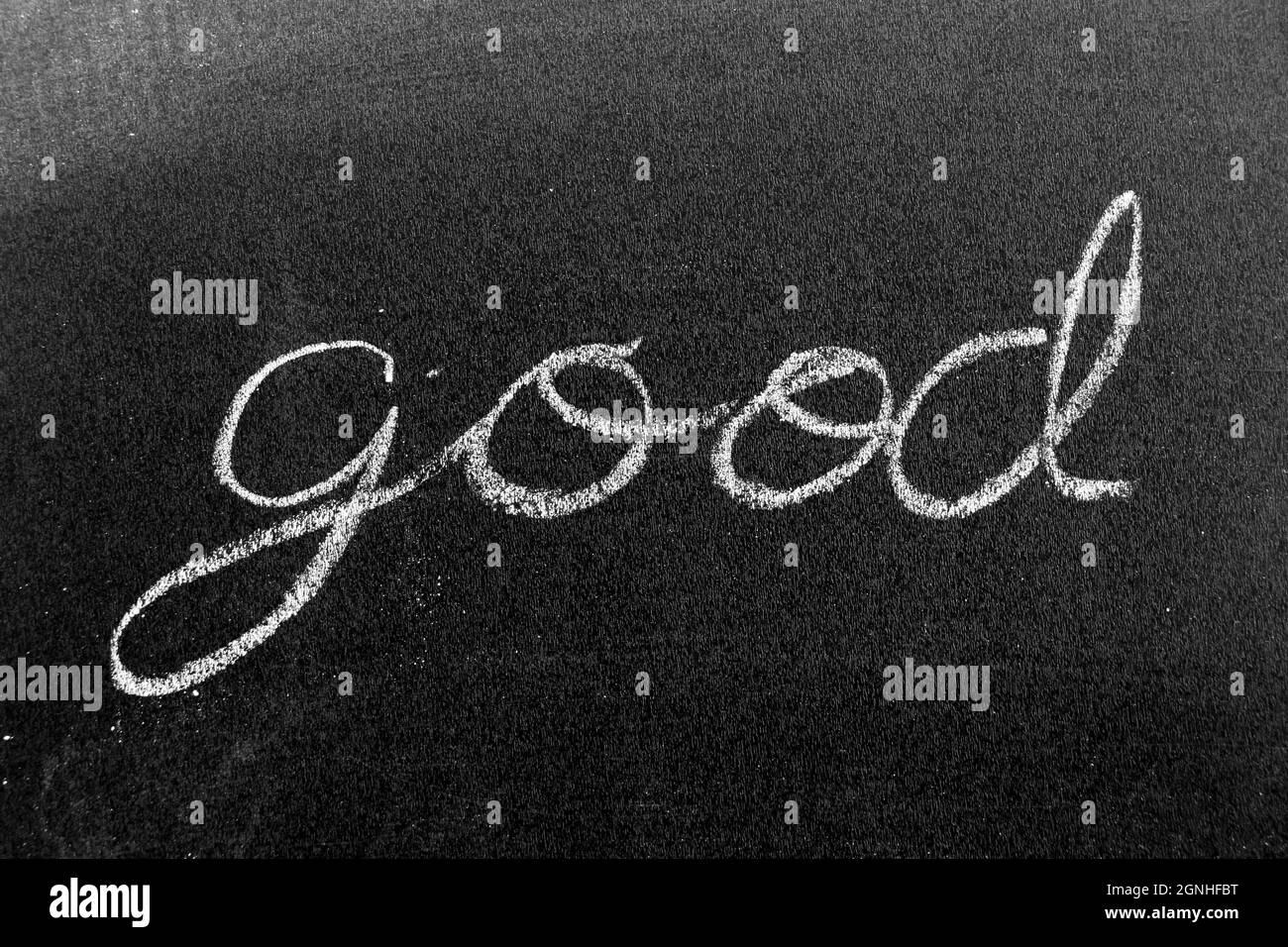 White color chalk hand writing in word good on black board background ...