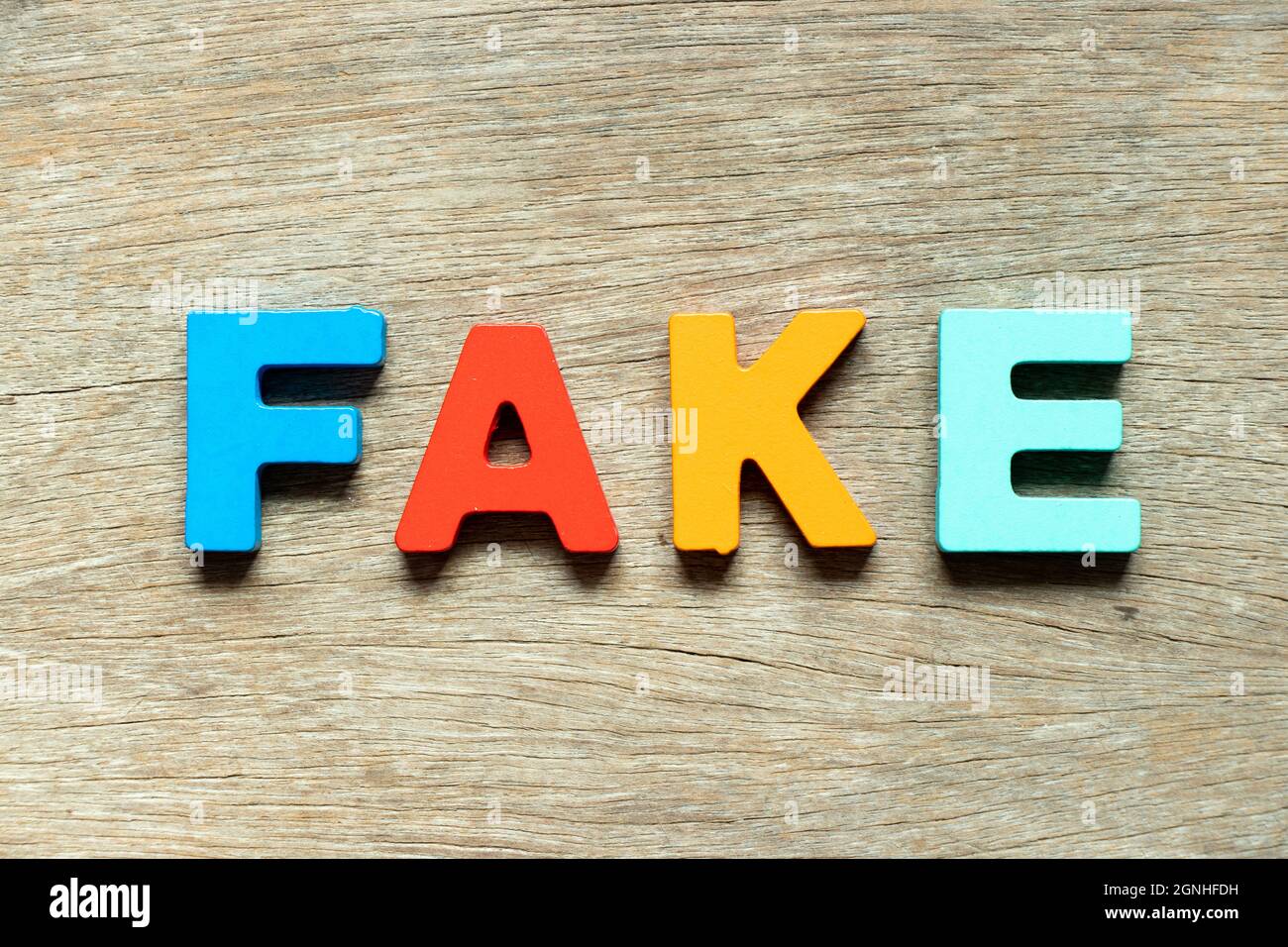 Color alphabet letter in word fake on wood background Stock Photo - Alamy