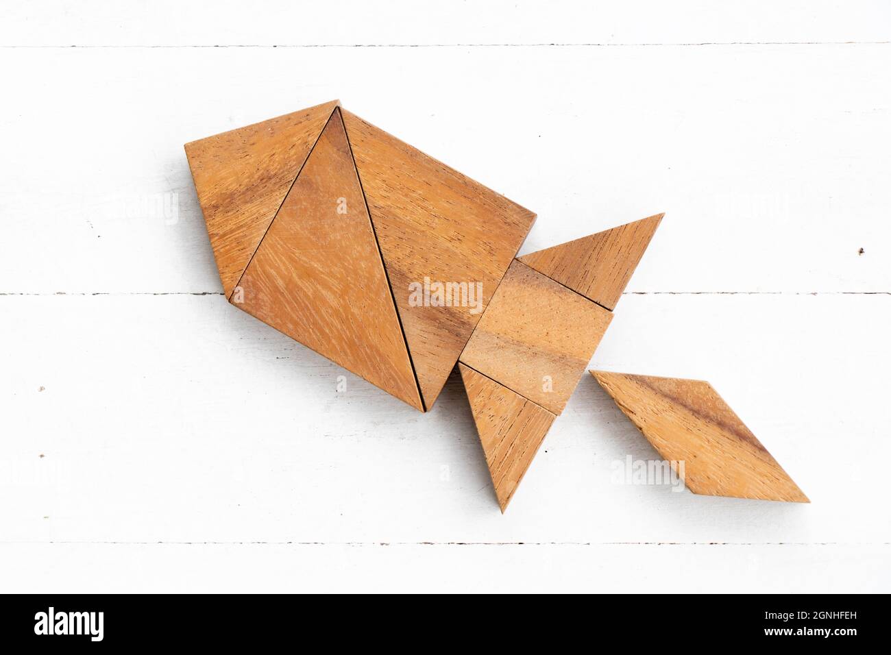 Wood tangram puzzle in rocket or missile shape on white wood background ...