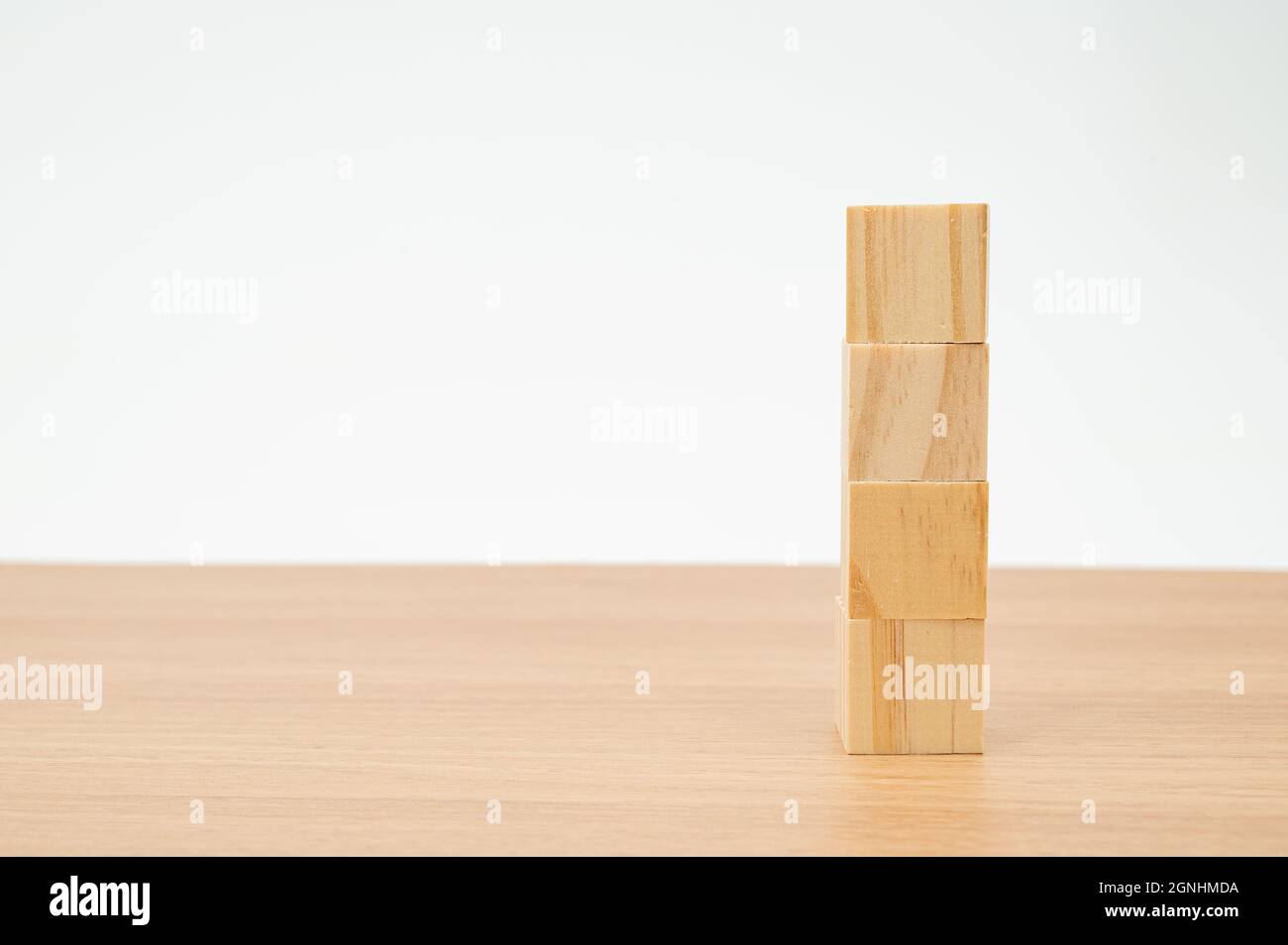Wooden cubes stacked up on a wooden table with a white background Stock ...