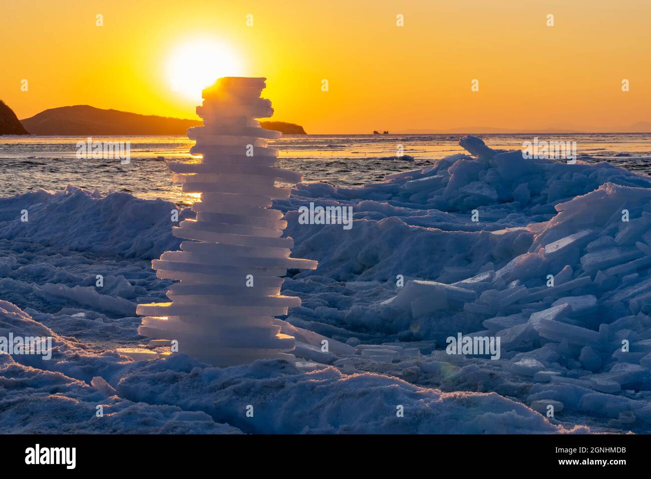 Ice pyramid on the background of a beautiful sunset over the frozen sea ...