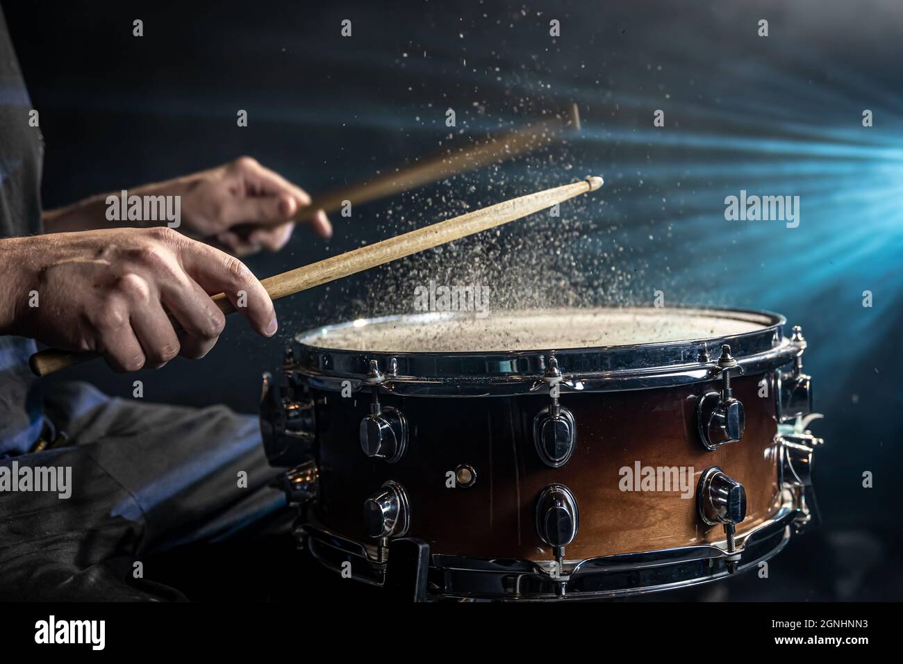 Drummer using drum sticks hitting snare drum with splashing water on ...
