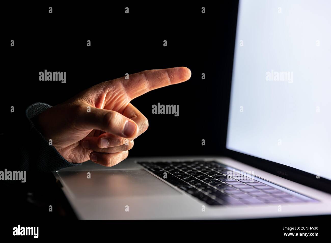Close up, male finger points at laptop screen in the dark Stock Photo ...