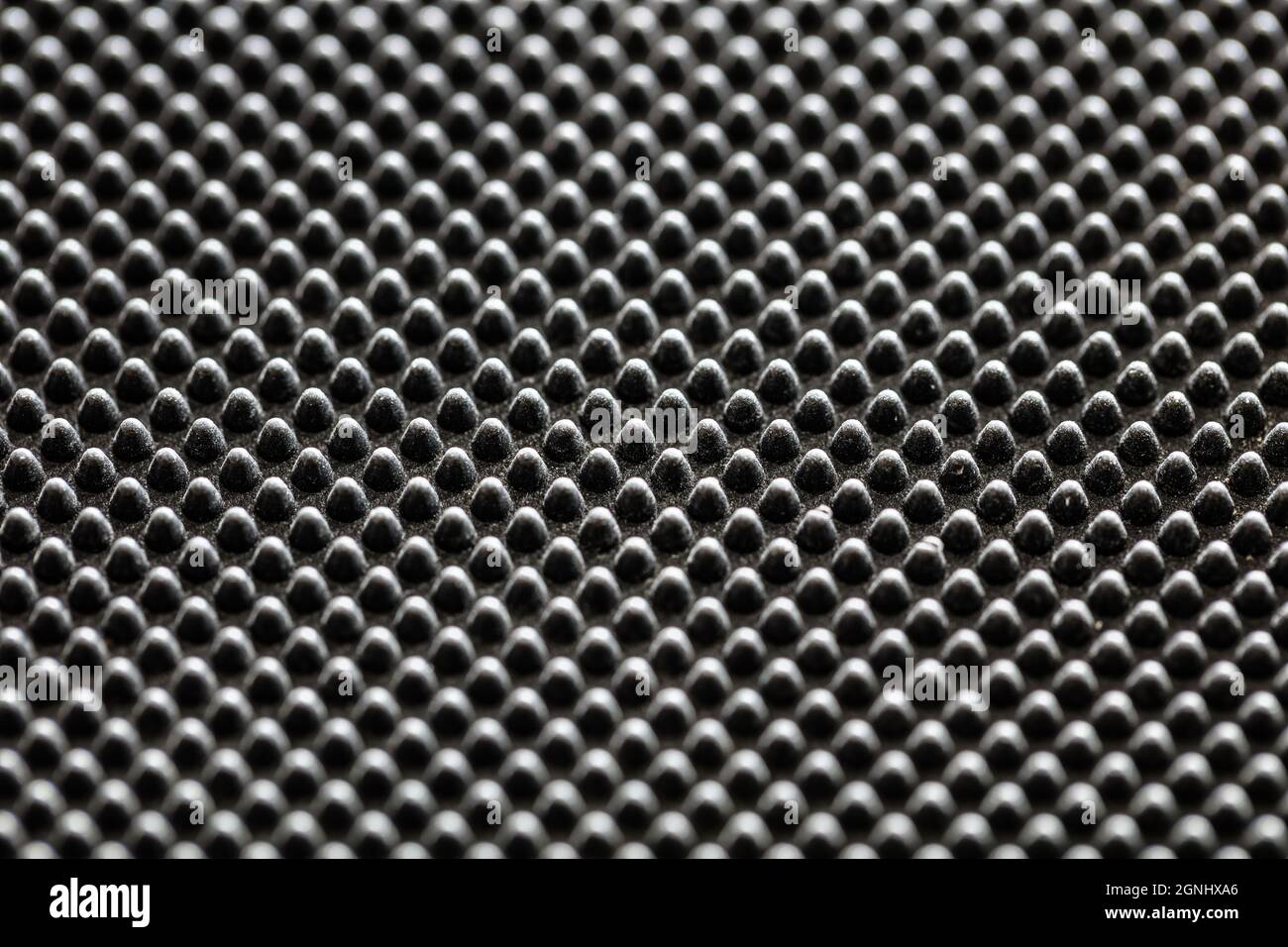 Black bumpy rubber surface used as a background. Black and white texture of rubber material with ...