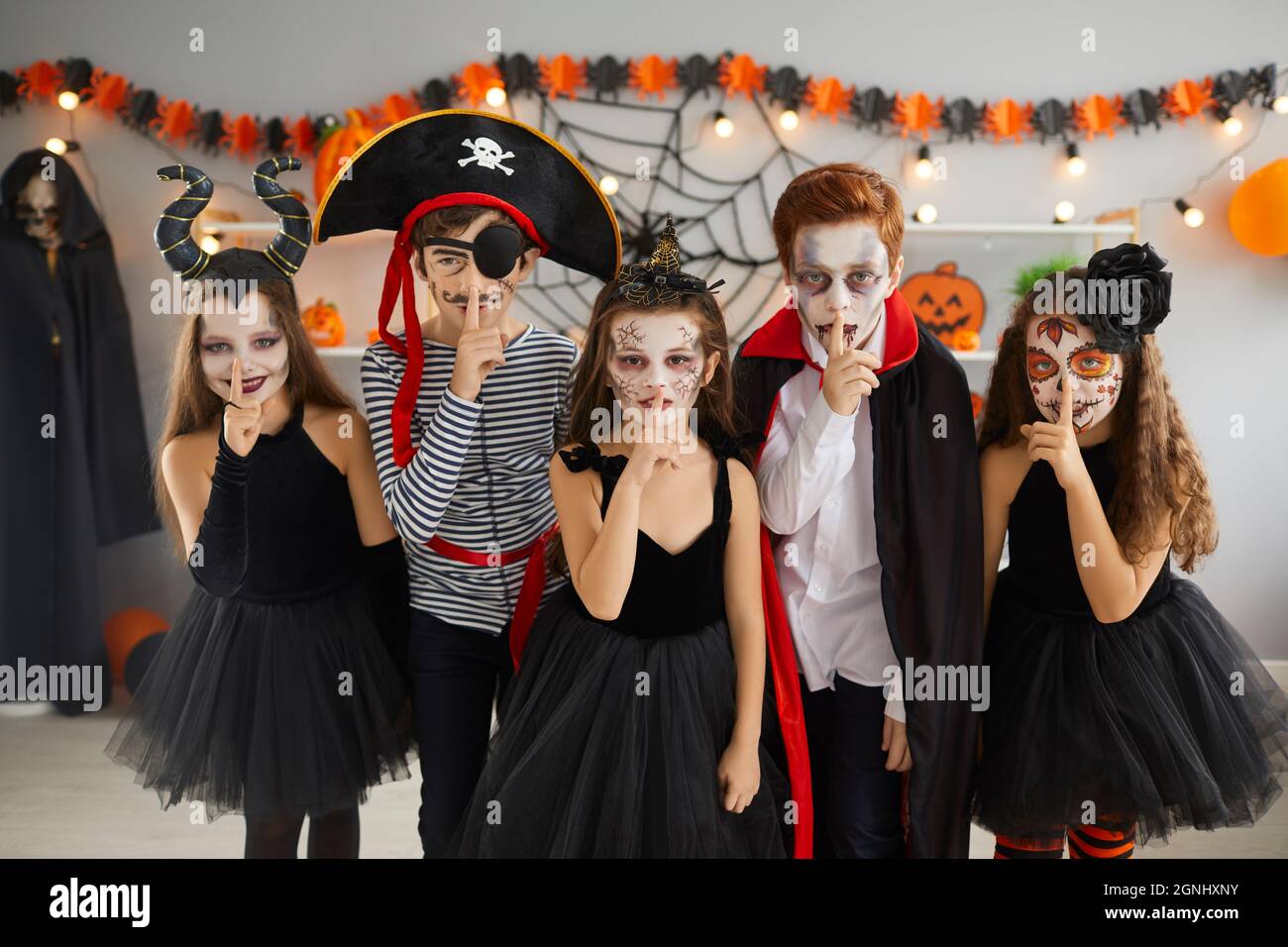 Kids in Halloween costumes doing finger on lip gesture to make you keep ...
