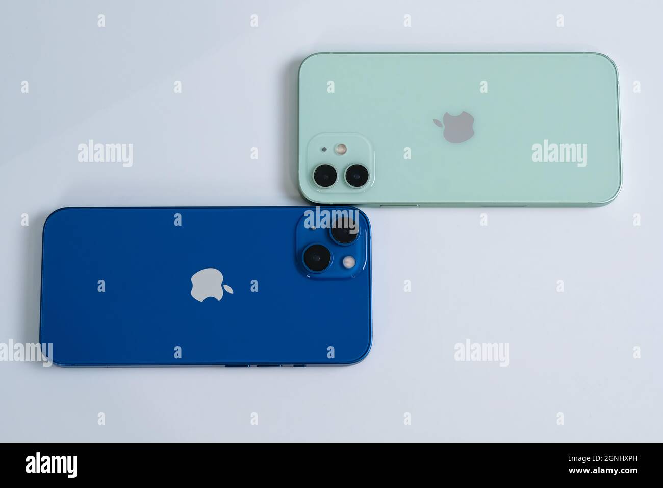 iPhone 13 in blue and iPhone 12 in green Stock Photo - Alamy