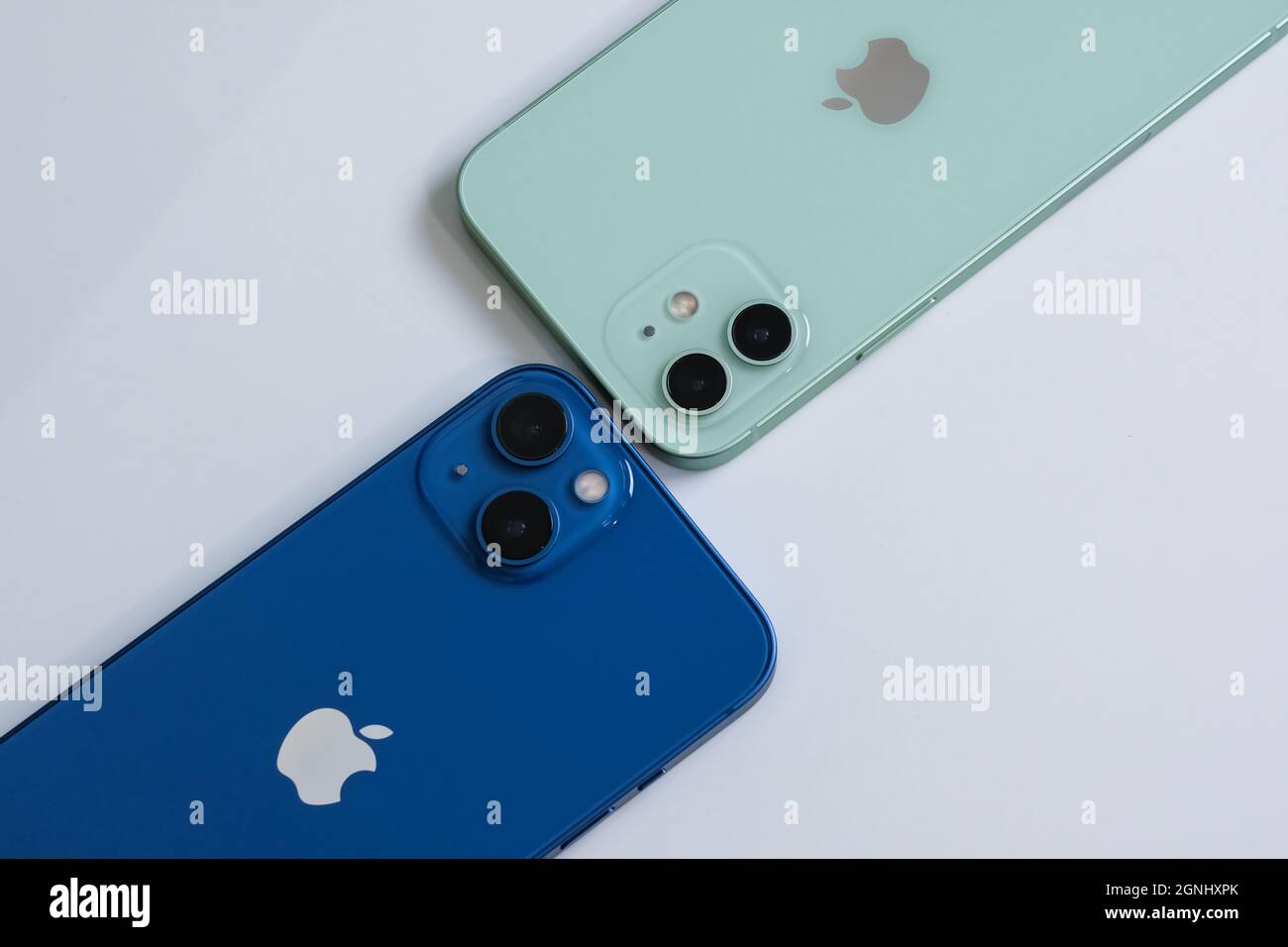 iPhone 13 in blue and iPhone 12 in green Stock Photo - Alamy