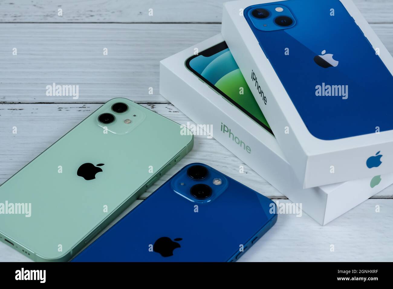 iPhone 13 in blue and iPhone 12 in green Stock Photo - Alamy